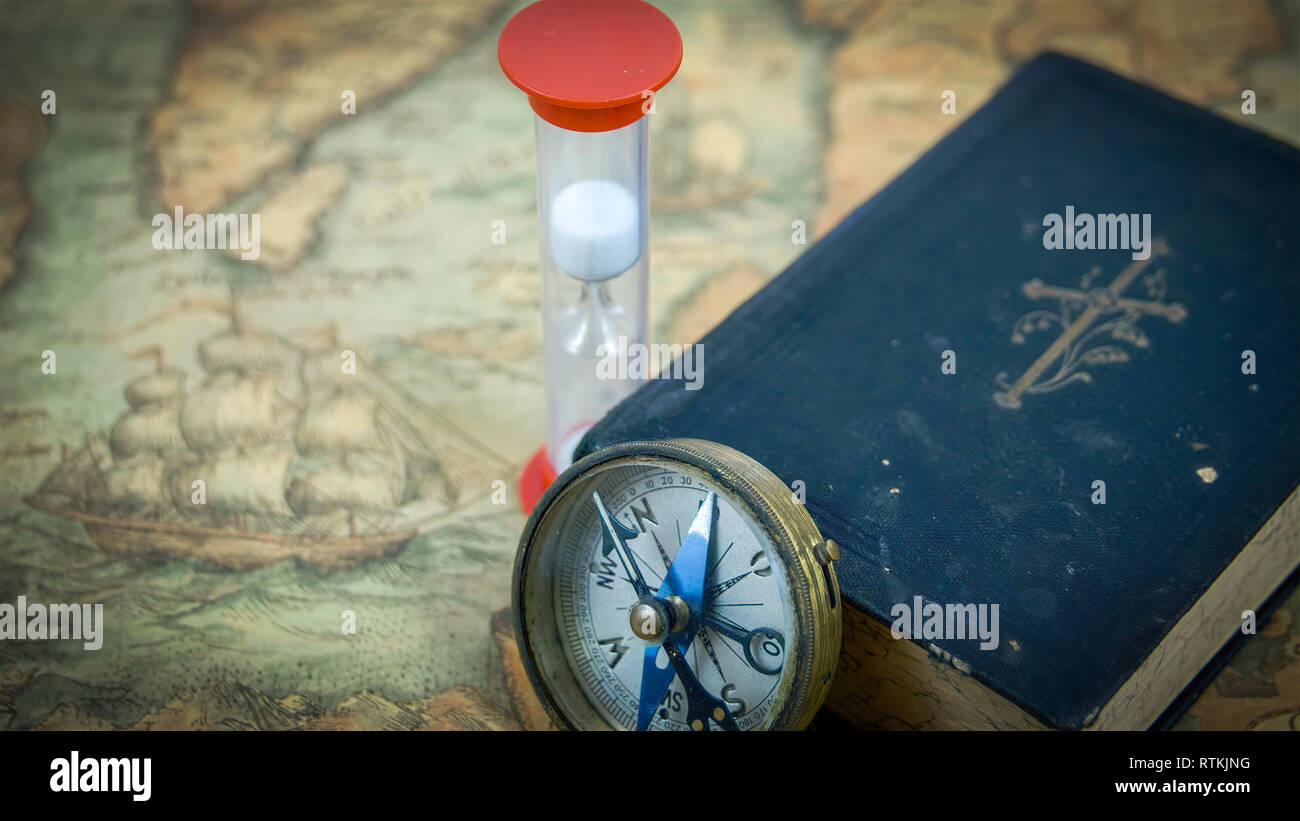 A compass hourglass and a bible on a navigational map. These things can ...