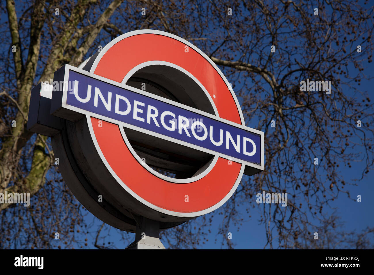 London Underground sign outside Seven Sisters station, London. Blue sky ...
