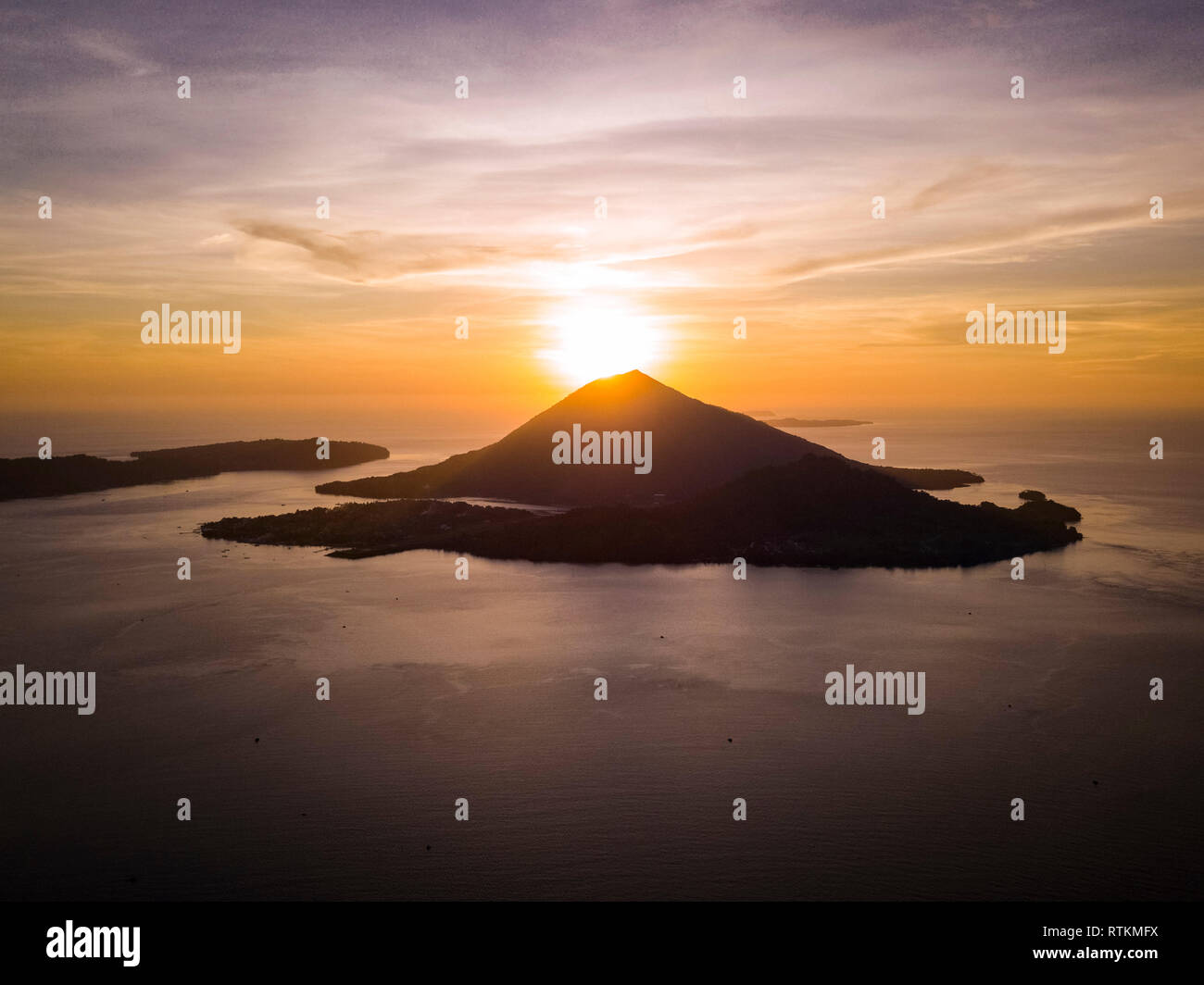 Banda Api, an active volcanic island, silhouetted against sunset, Banda ...
