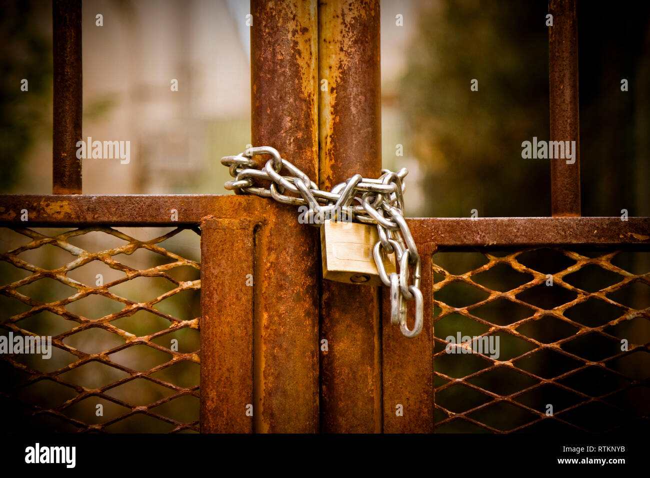 Rusty metal gate of a factory closed with padlock - concept image Stock ...