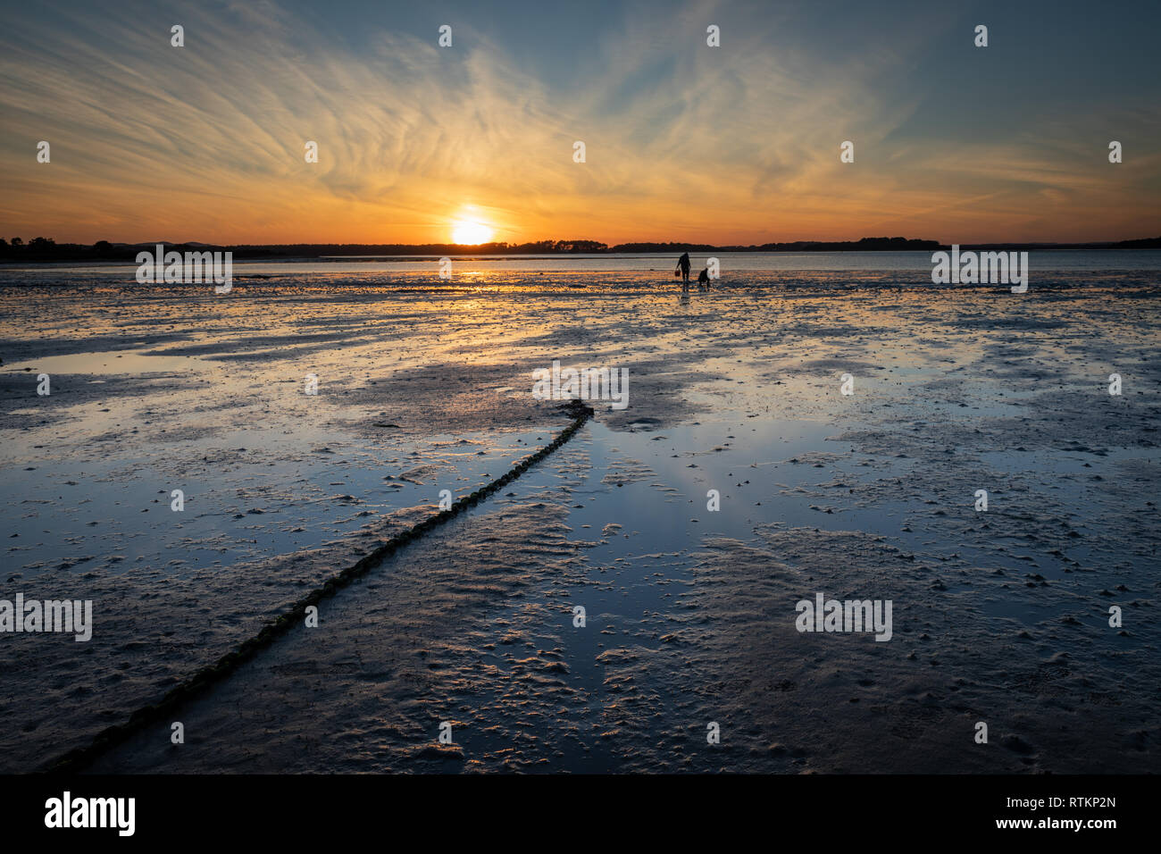 Beautiful sunset over bay with tide out and anchor chain Stock Photo ...