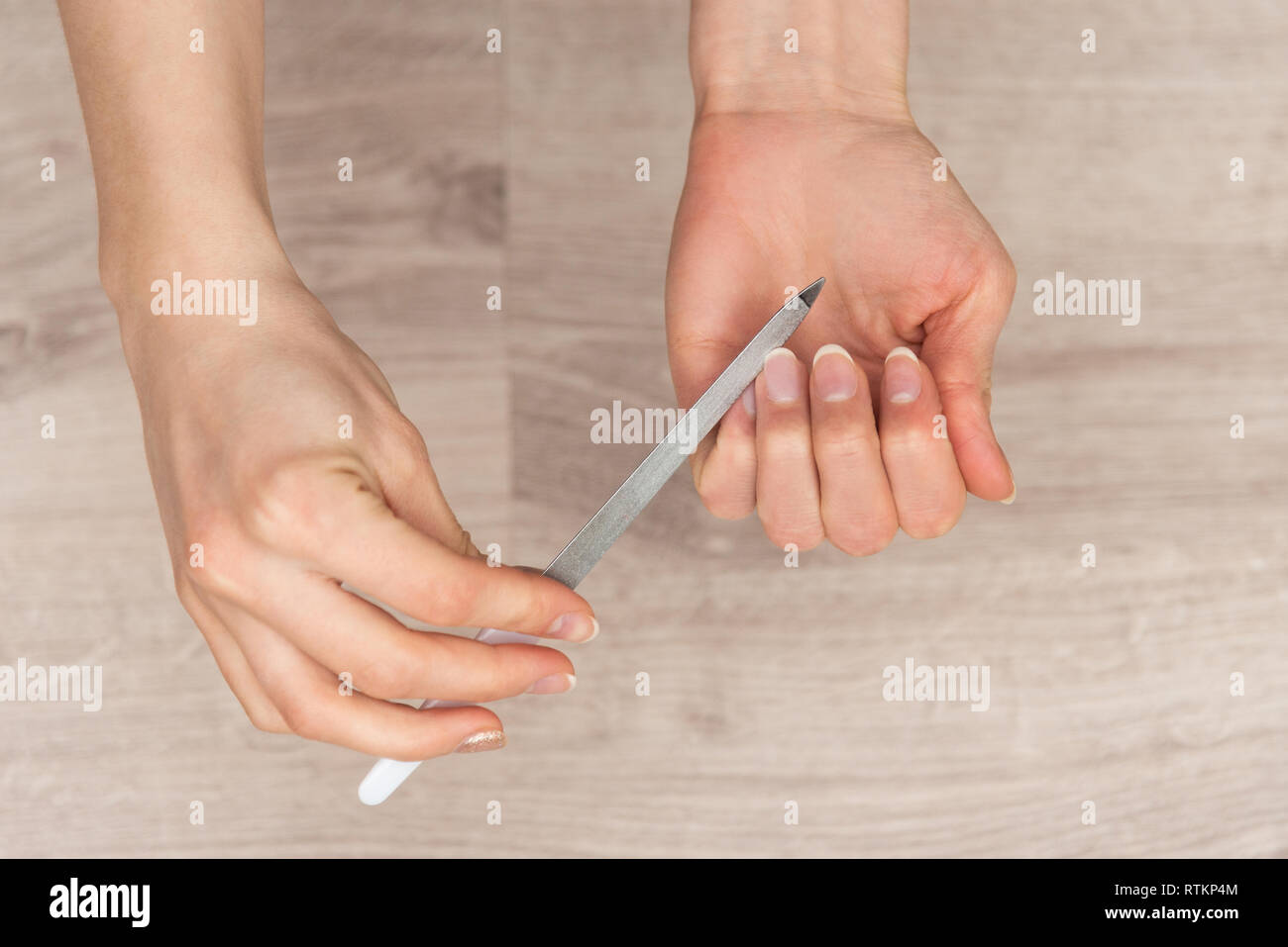 Manicure on female hands. A woman makes a manicure. Nail file in female ...