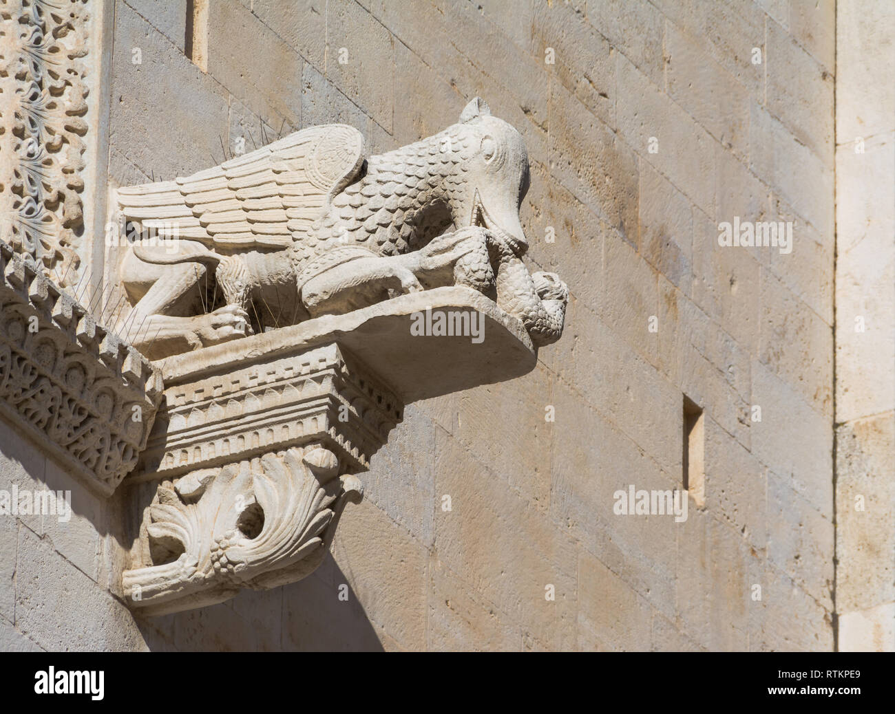 Gargoyle eating snake Stock Photo - Alamy