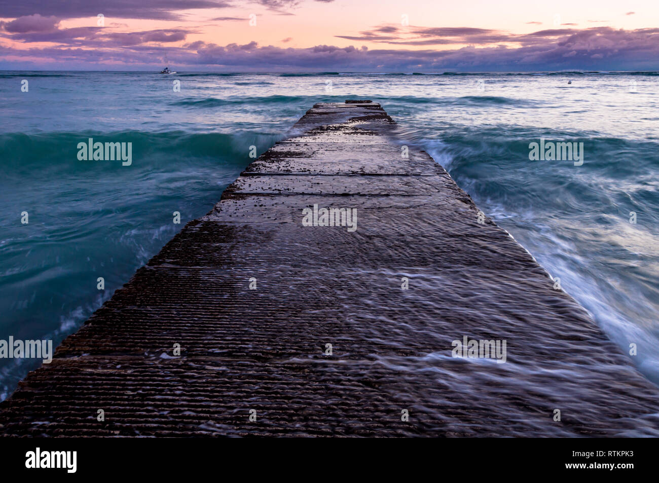 Water washing over a breakwater on famous Waikiki beach in Honolulu ...