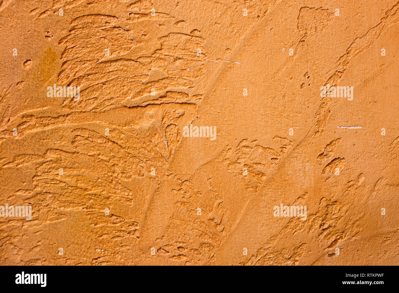 Close-up of colorful golden bronze plastered uneven stucco wall ...