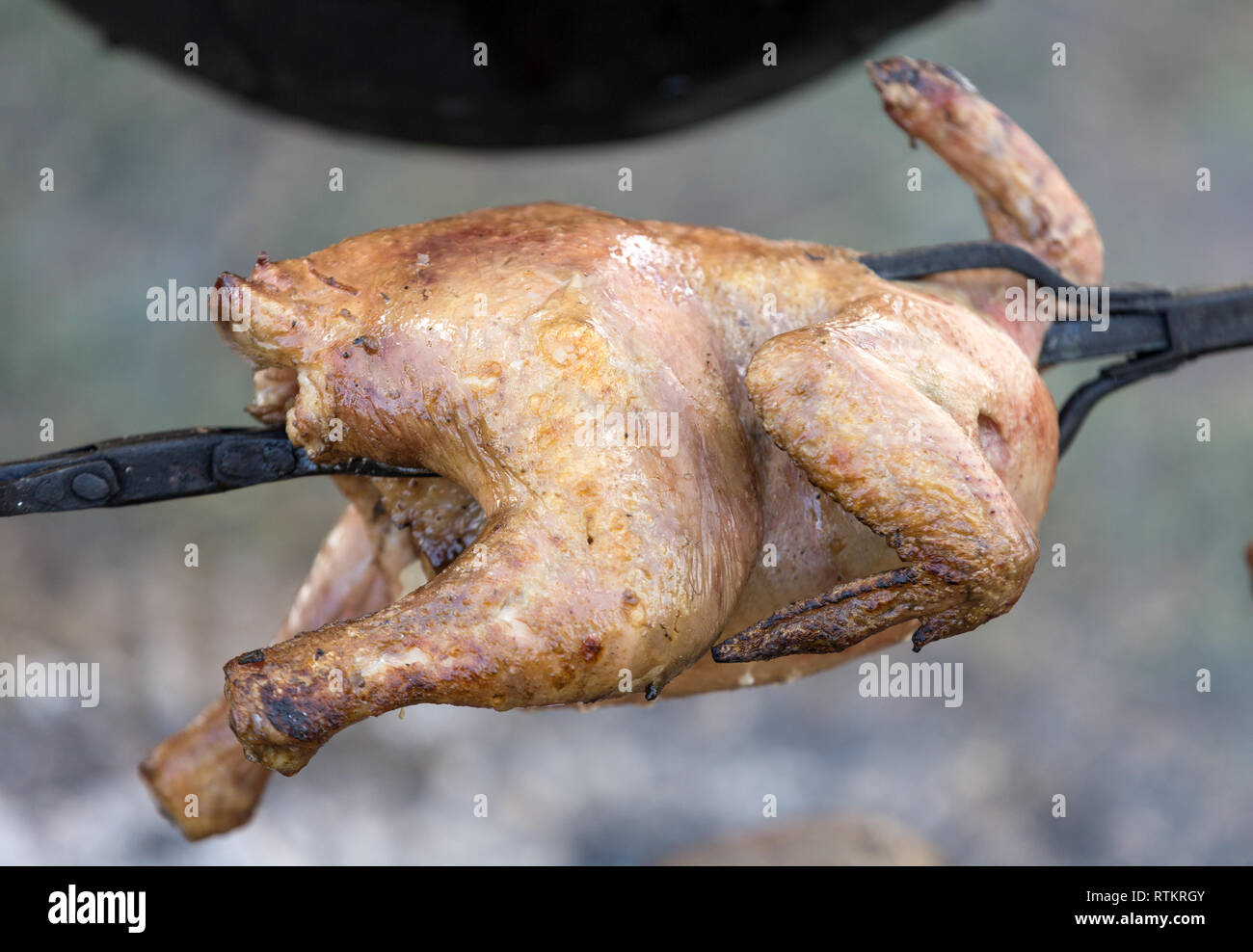 Whole chicken being roasted on an open fire Stock Photo - Alamy