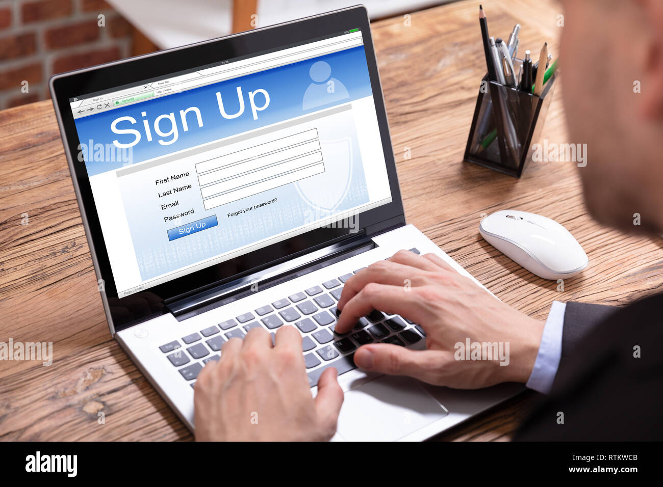 Businessman's Hand Signing Into Website On Laptop In Office Stock Photo ...