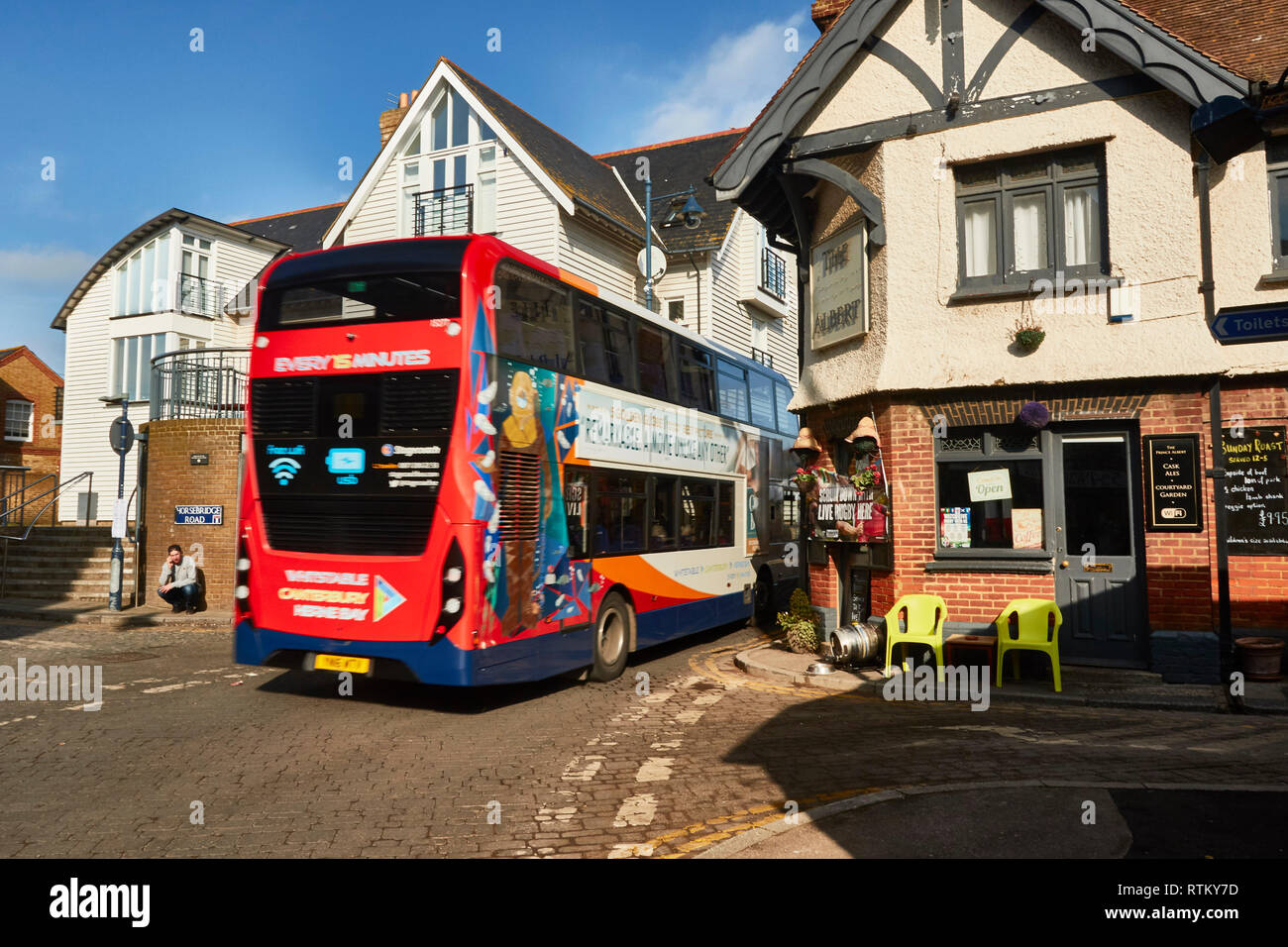 Colourful Canterbury bus driving through Whitstable street, Kent ...