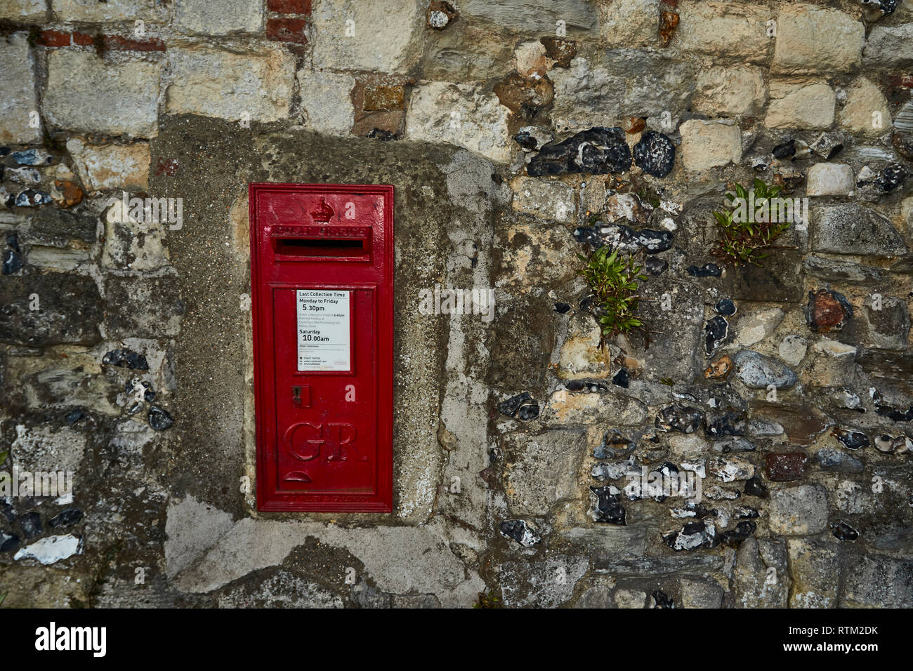 Red postal box built into stone wall, Canterbury, Kent, England, United ...