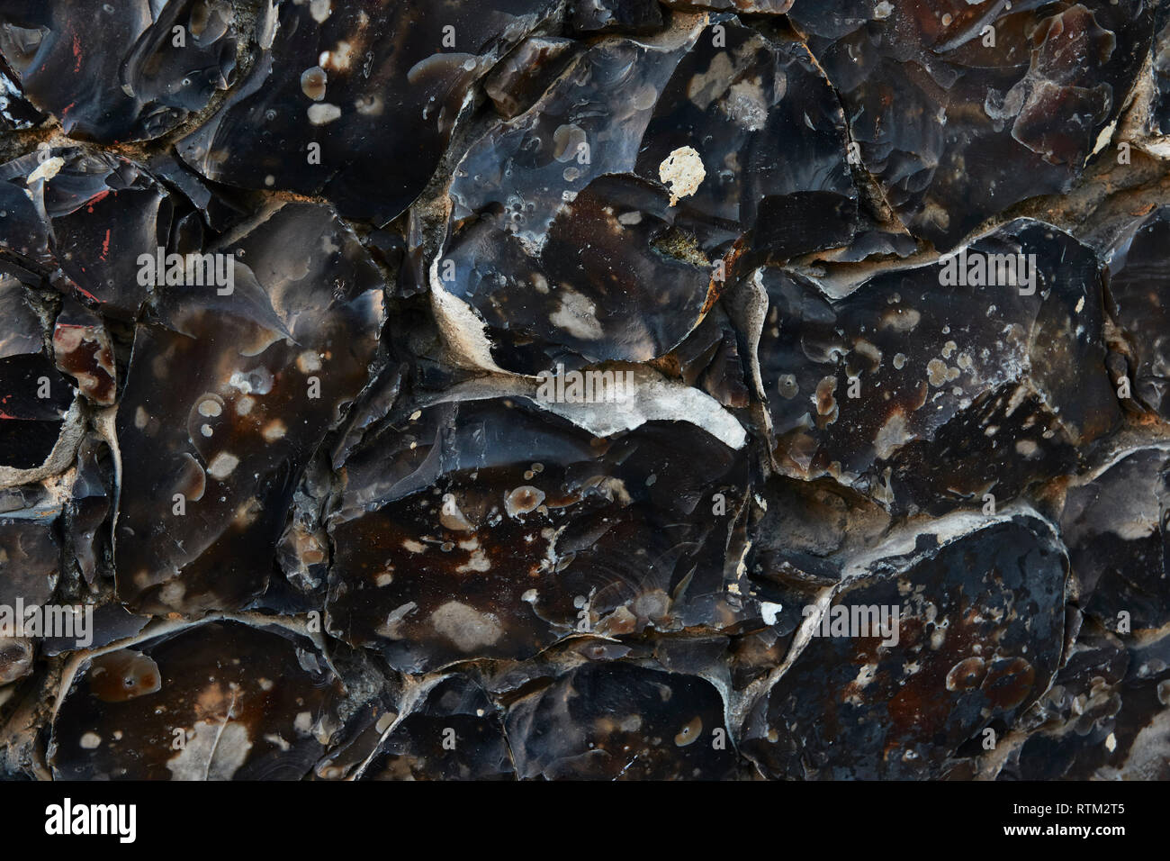 Flint rock abstract pattern built into a wall in southern England ...