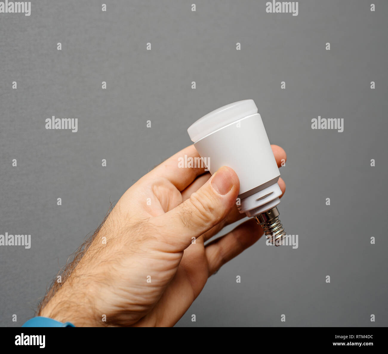 Intelligent light bulb in man hands against gray background Stock Photo ...