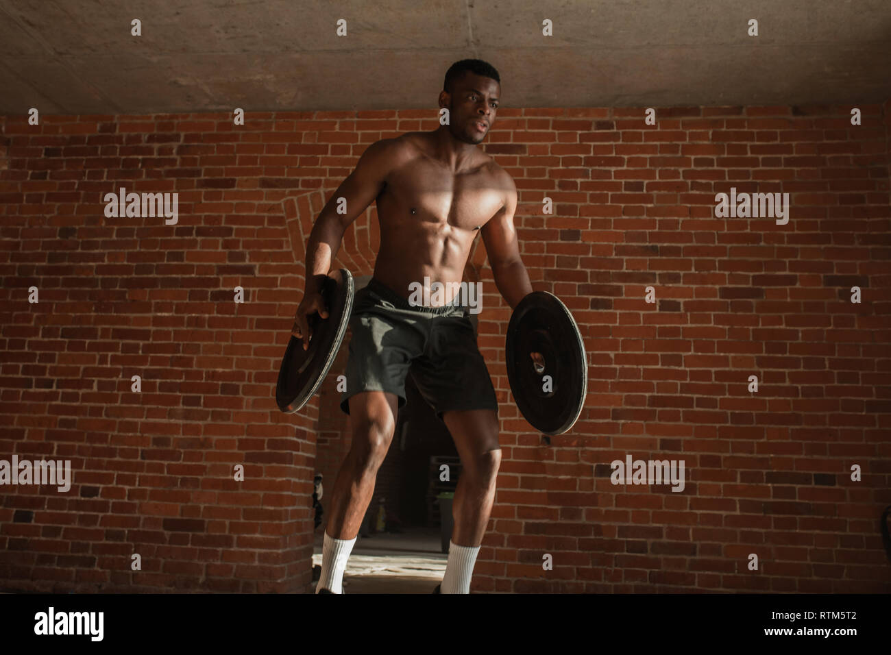 Athletic dark-skinned fitness coach working out with crossfit jumps on ...
