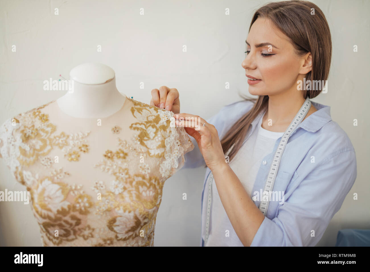 Portrait of a caucasian attractive dressmaker creating a wedding dress ...