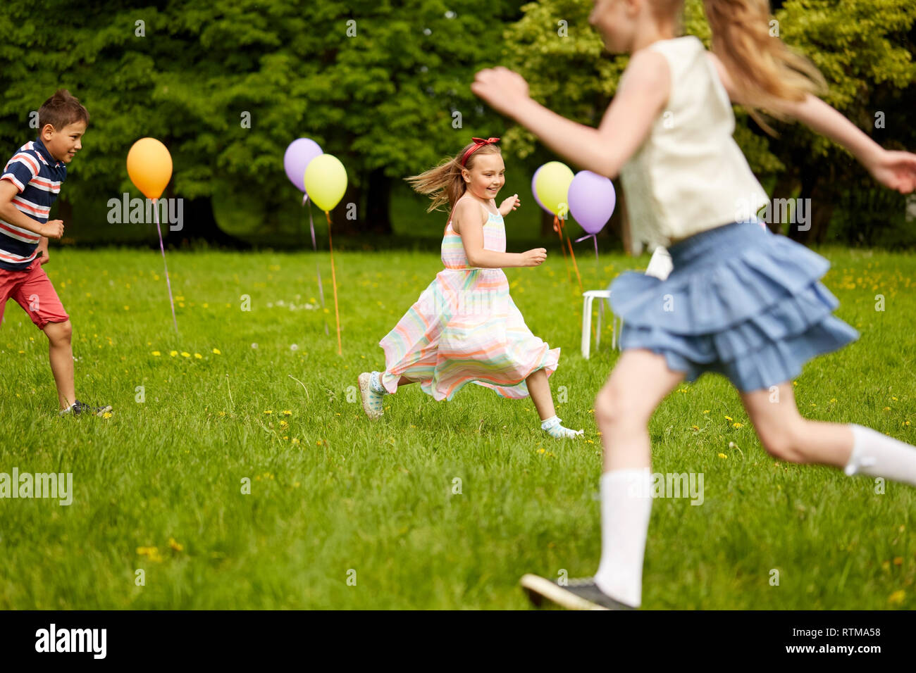 happy kids playing tag game at birthday party Stock Photo - Alamy