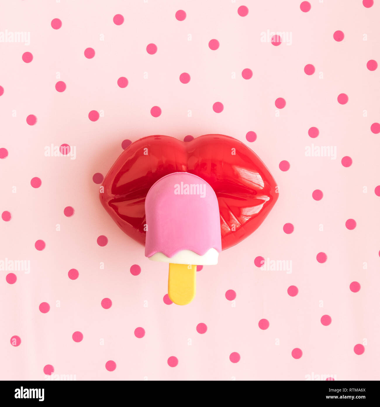 Lips with ice cream on stick against pink polka design background ...