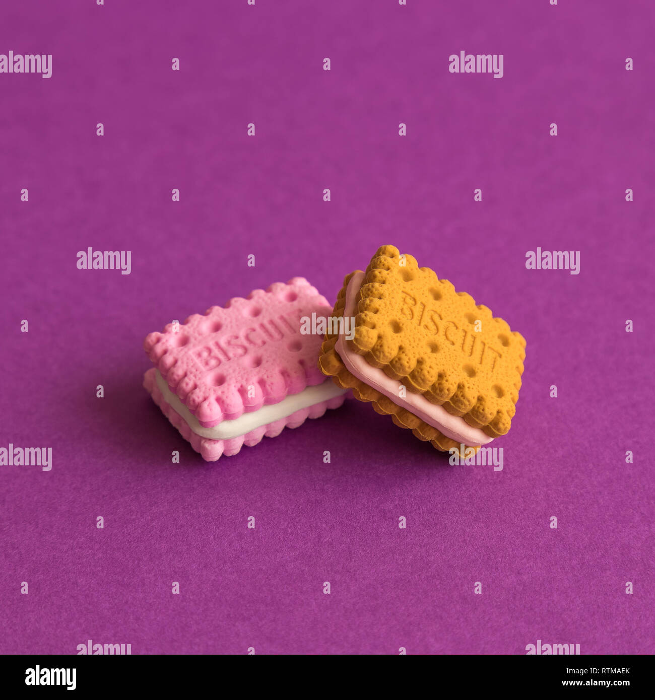Flat lay of colorful biscuits made of rubber against purple background ...
