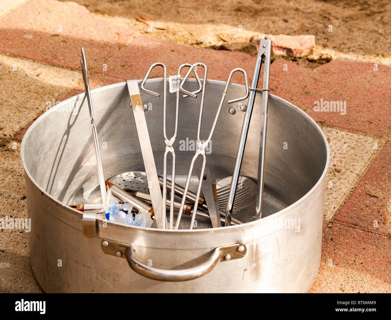 A stainless steel casserole with cooking utensils Stock Photo - Alamy