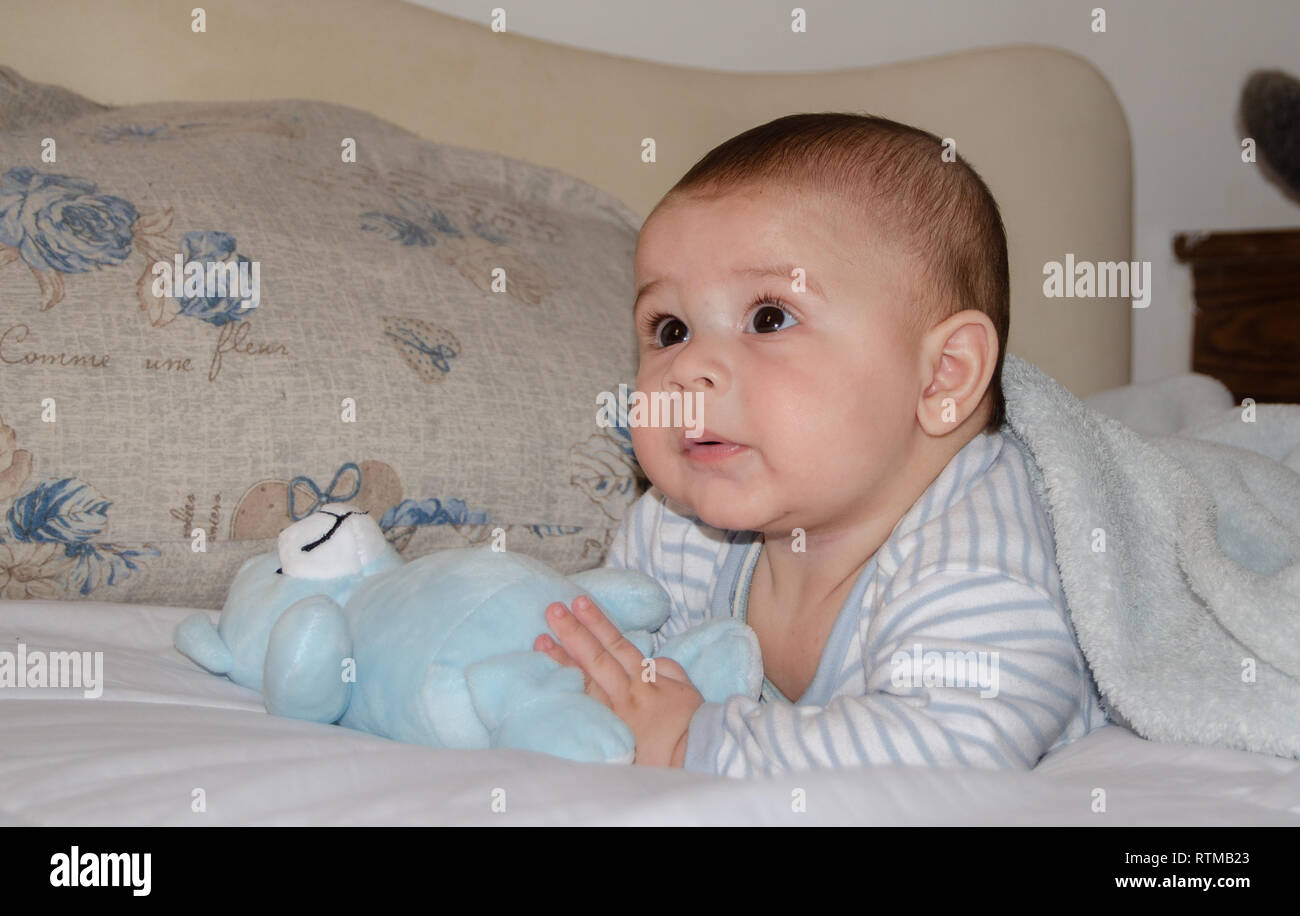 cute 4 months old baby boy having tummy time and making funny faces ...