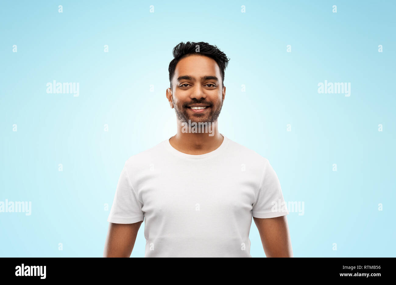 smiling young indian man over blue background Stock Photo - Alamy
