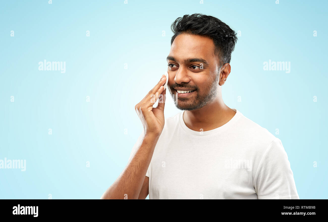 smiling indian man cleaning face with cotton pad Stock Photo - Alamy
