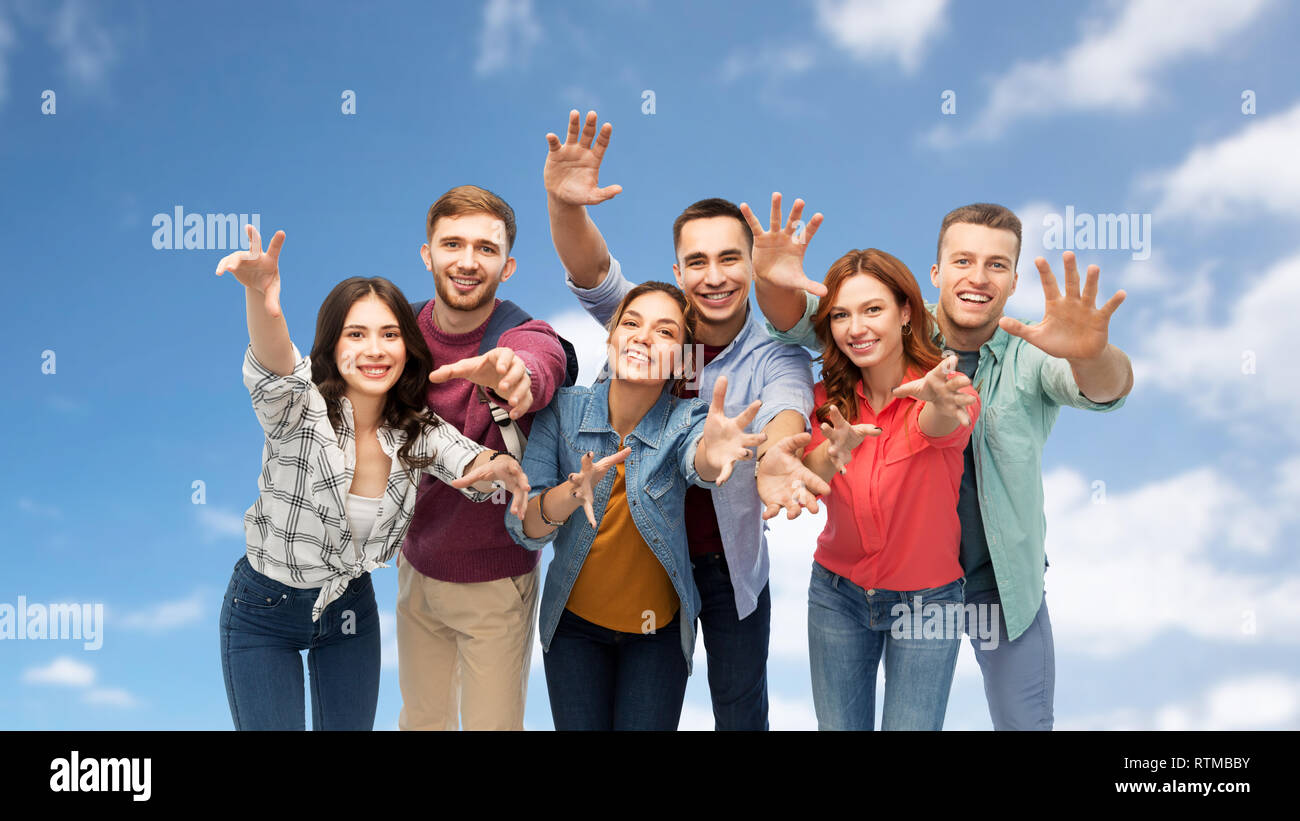 group of happy students over blue sky background Stock Photo - Alamy