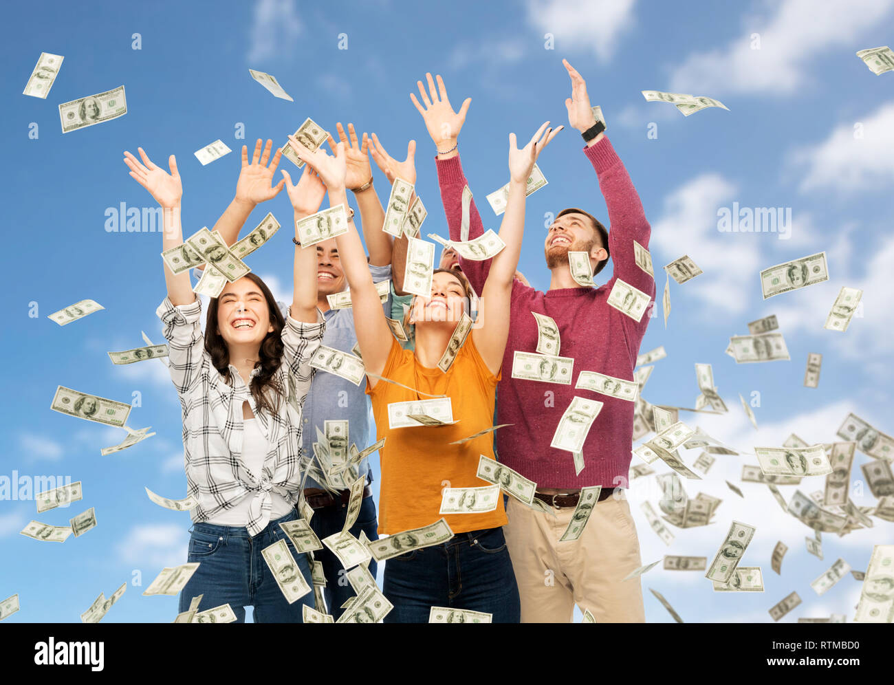 happy friends picking money falling from up above Stock Photo - Alamy