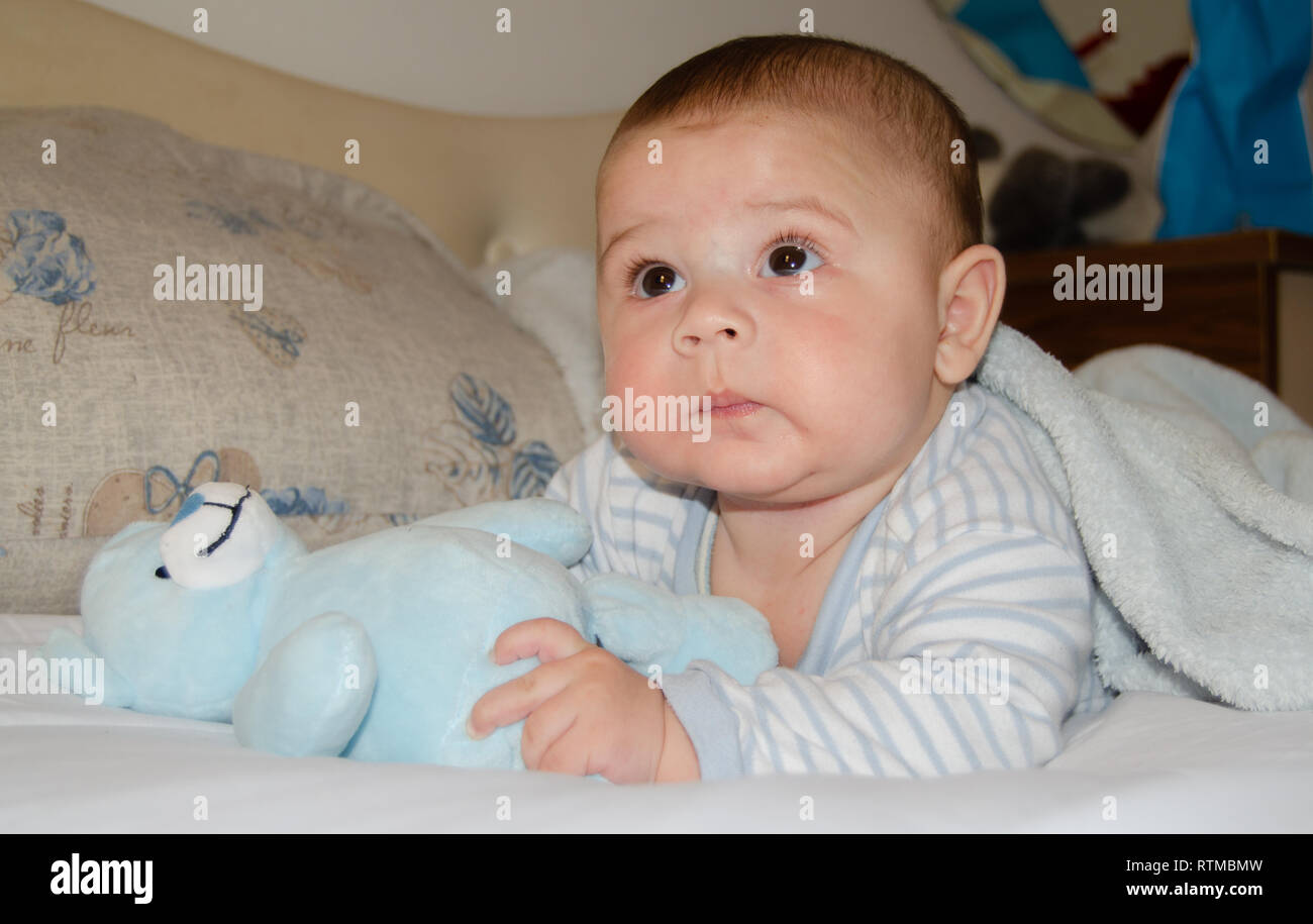 cute 4 months old baby boy having tummy time and making funny faces ...
