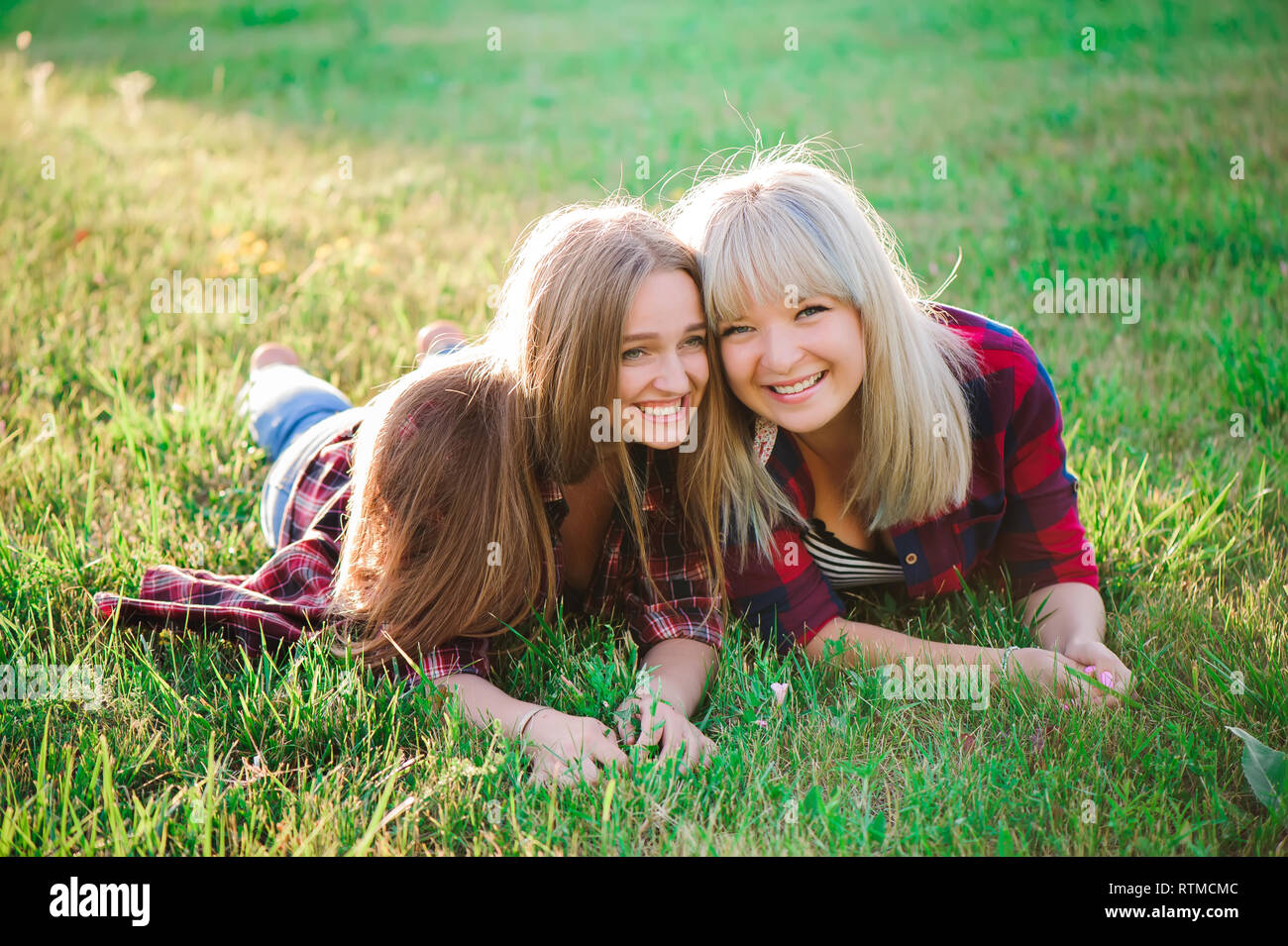 Two happy female friends playing and having fun in green grass Stock ...