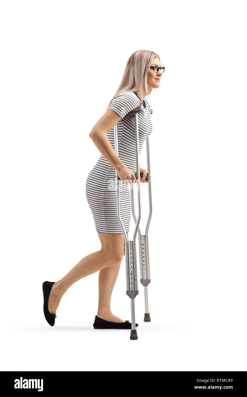 Full length shot of a young woman walking with crutches isolated on ...