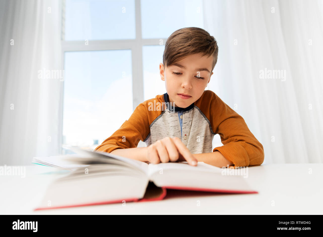 Boy reading at table hi-res stock photography and images - Alamy