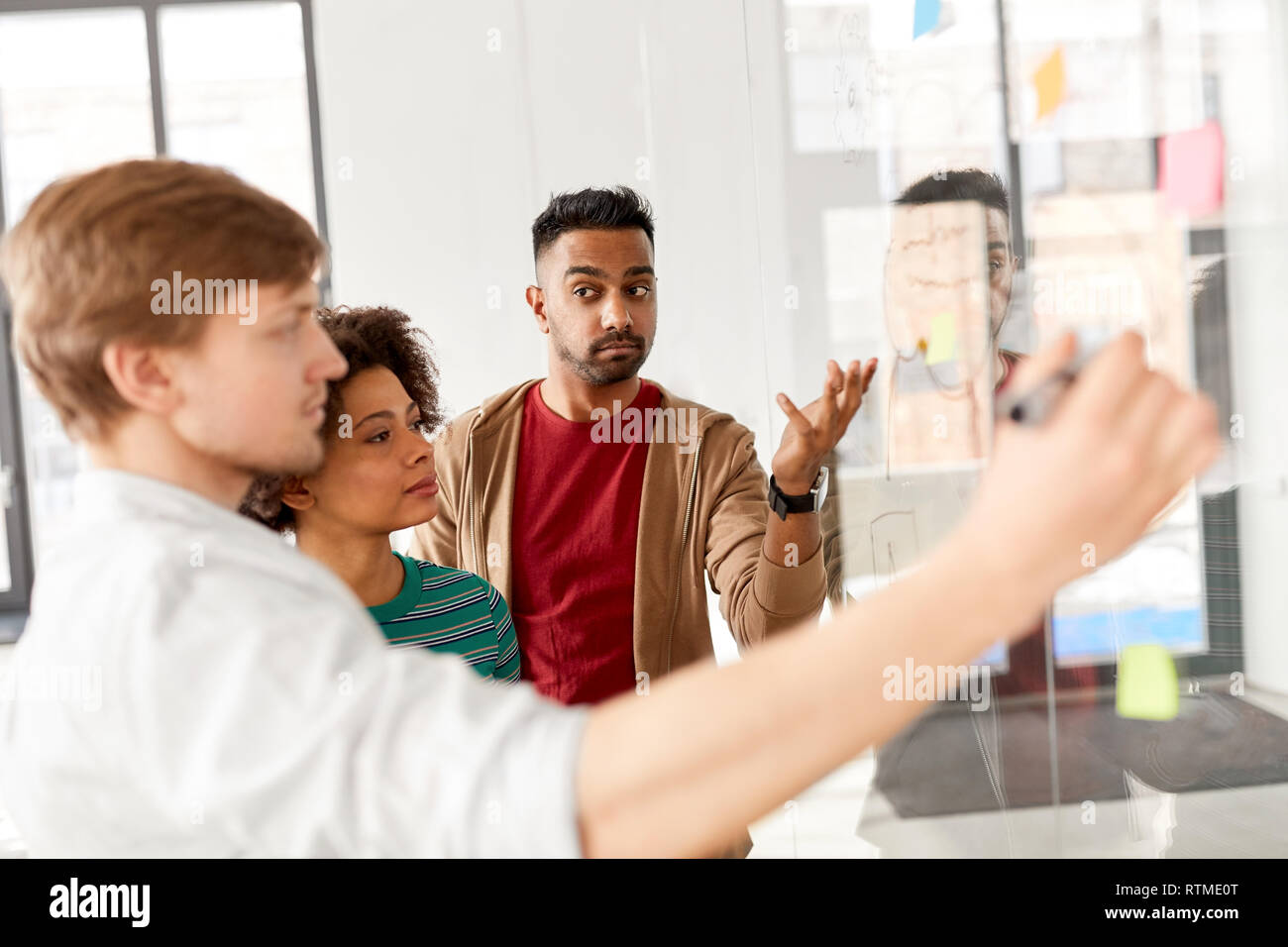 creative team with scheme at office glass board Stock Photo - Alamy