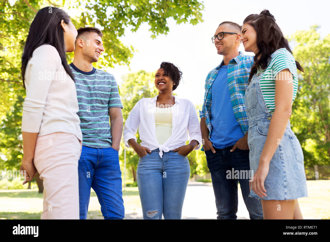 happy international friends talking in park Stock Photo - Alamy