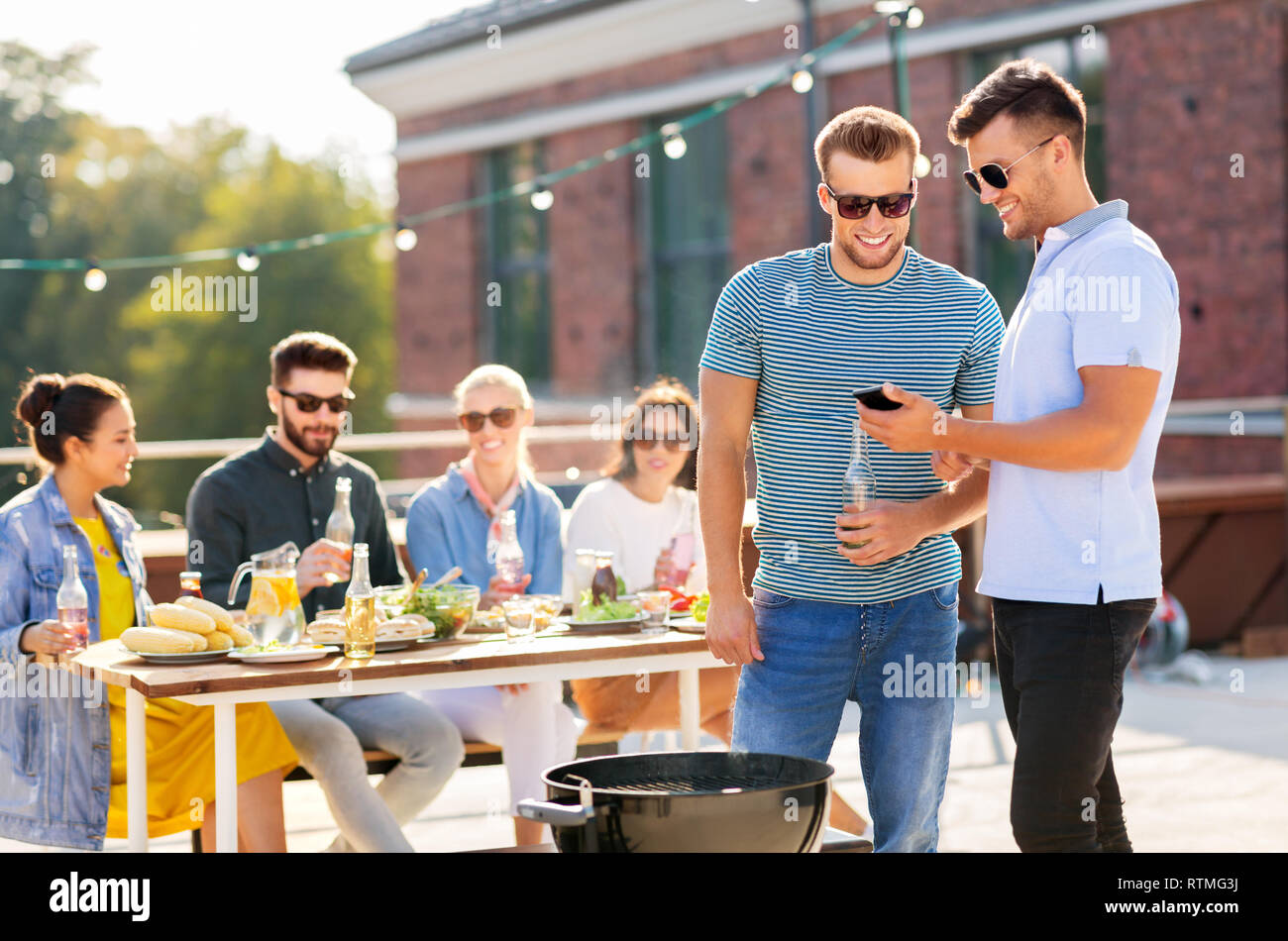 happy friends having bbq party on rooftop Stock Photo - Alamy