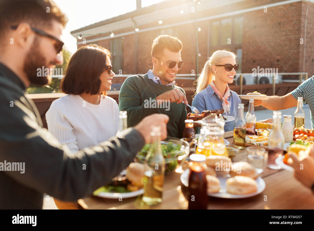 happy friends eating at barbecue party on rooftop Stock Photo - Alamy