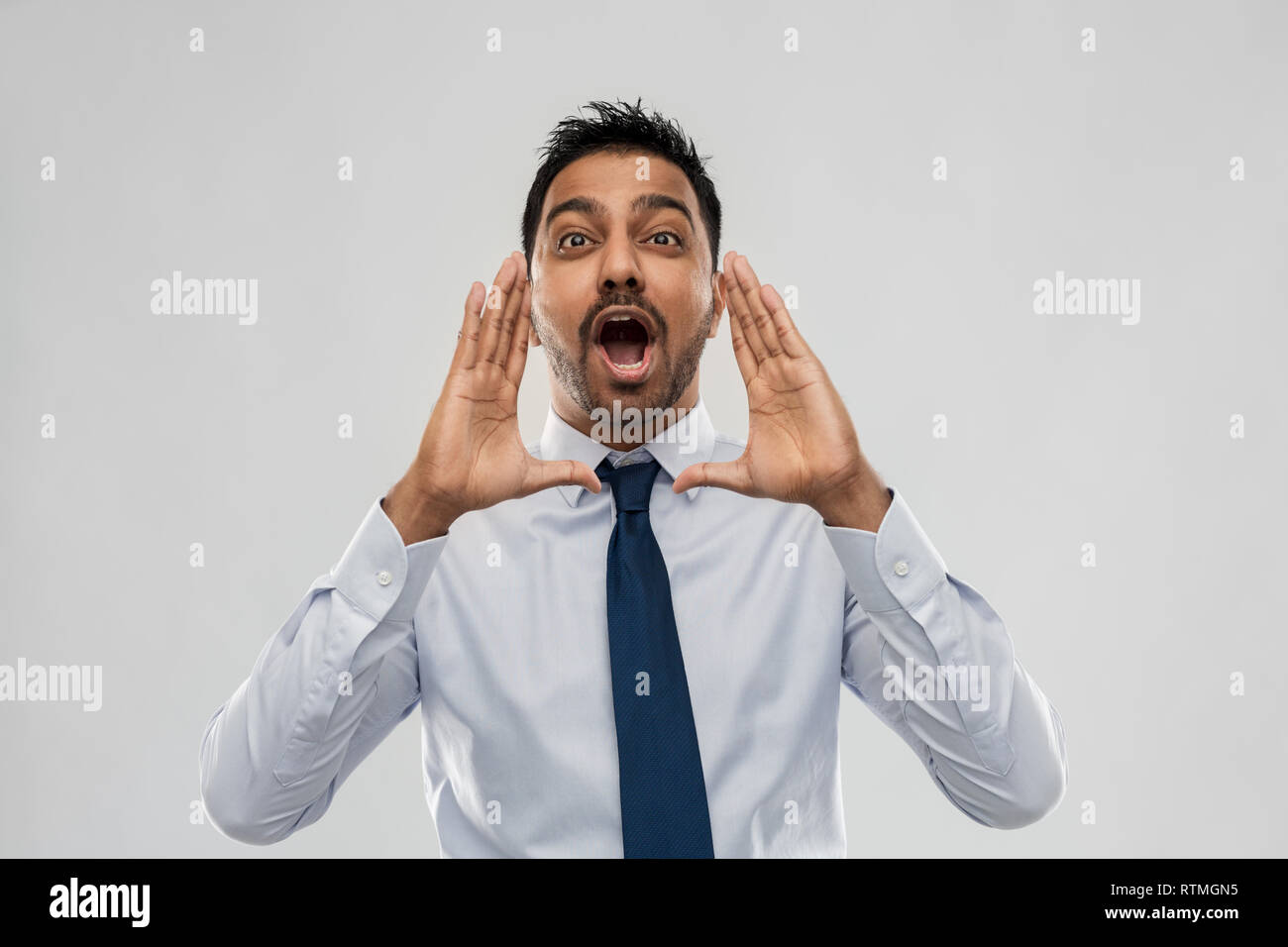 indian businessman shouting or calling over grey Stock Photo - Alamy