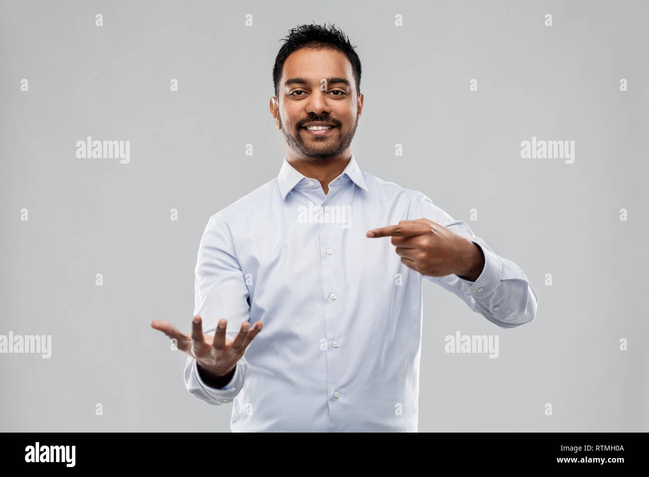 indian businessman holding something invisible Stock Photo - Alamy