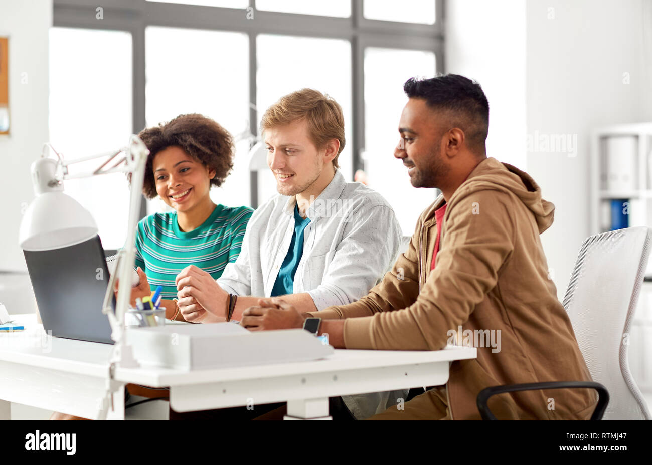 happy creative team with laptop working at office Stock Photo - Alamy