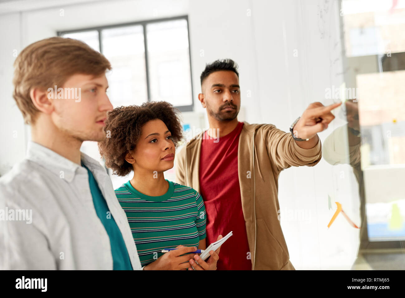 creative team looking at office glass board Stock Photo - Alamy