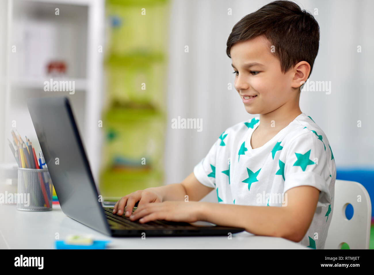 student boy typing on laptop computer at home Stock Photo - Alamy
