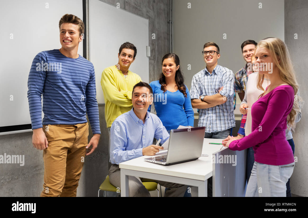 students and teacher with papers and laptop Stock Photo - Alamy