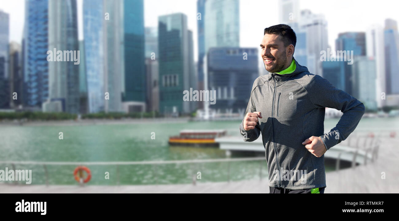 happy young man running over singapore city Stock Photo - Alamy