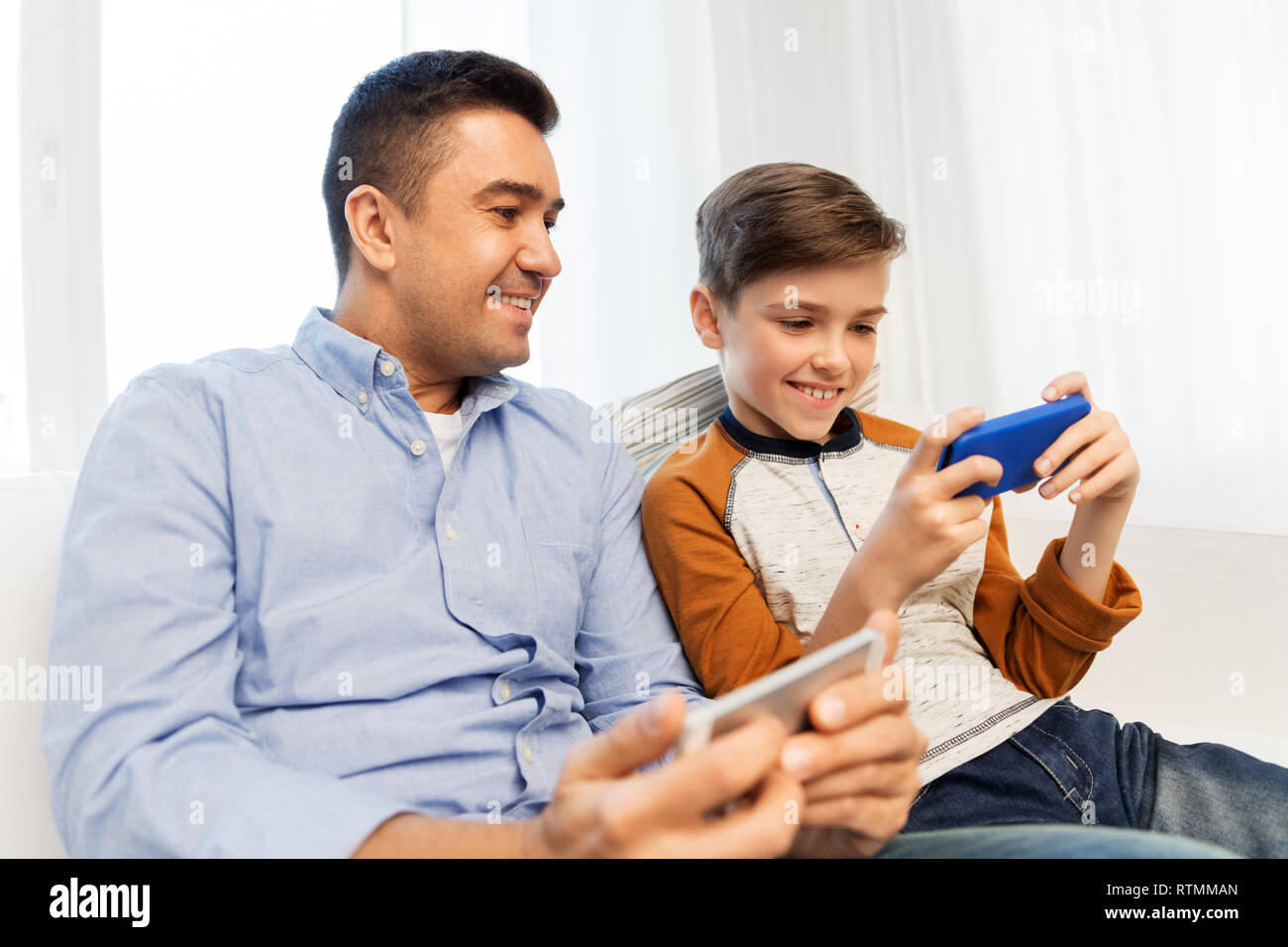 happy father and son with smartphones at home Stock Photo - Alamy