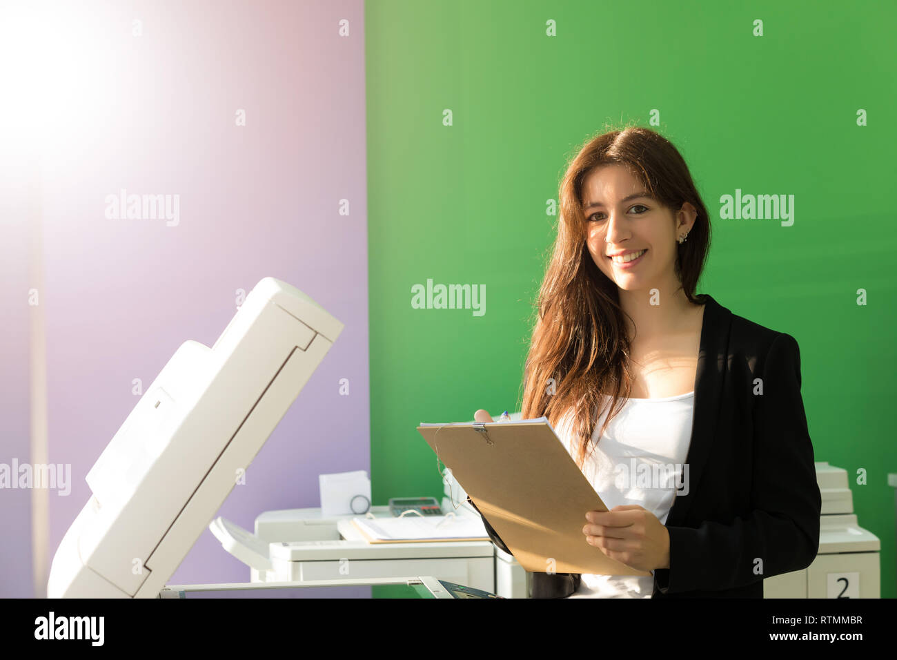 A young student at a copy center taking some copies for her final exams ...