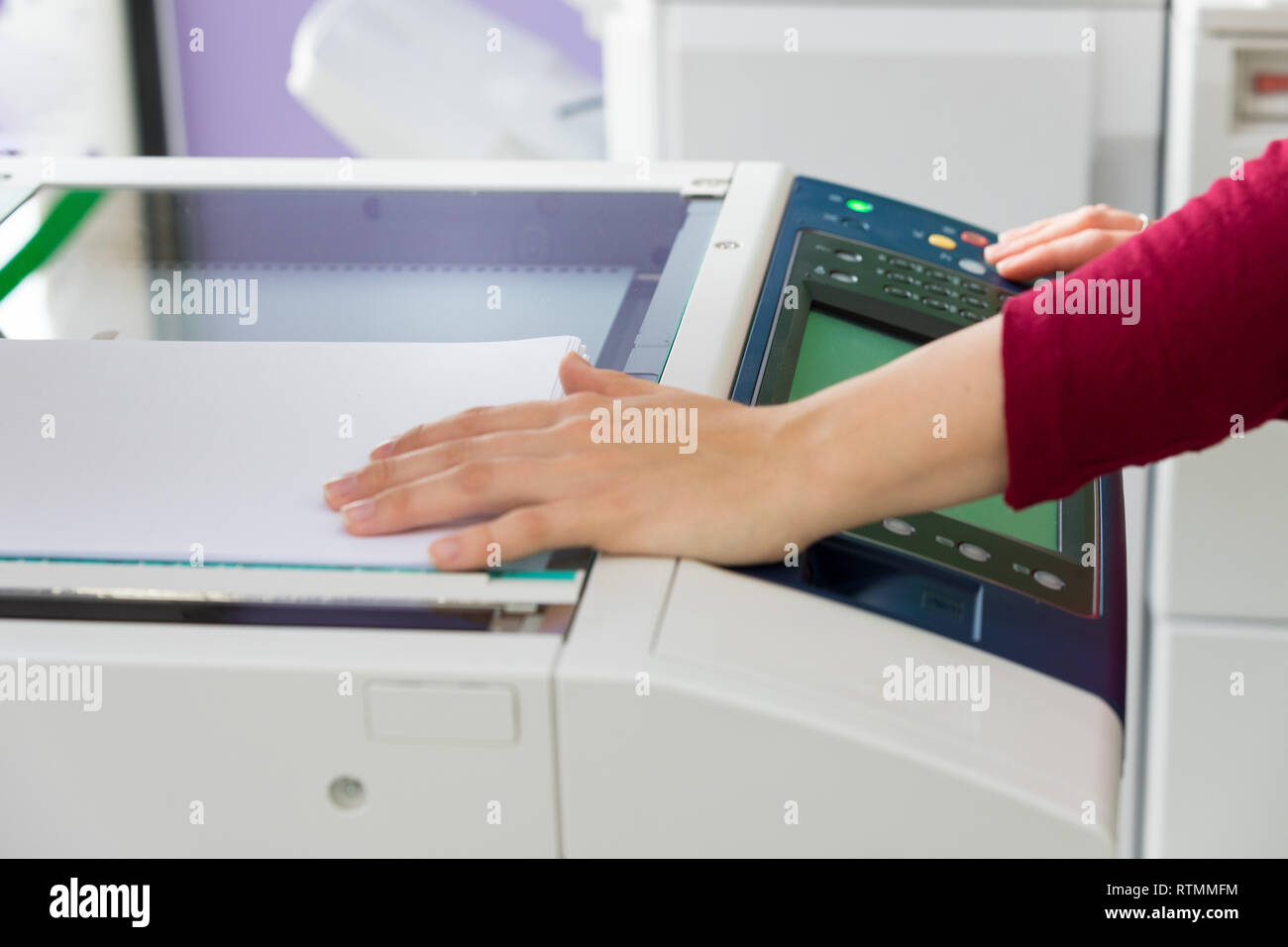 A young student at a copy center taking some copies for her final exams ...