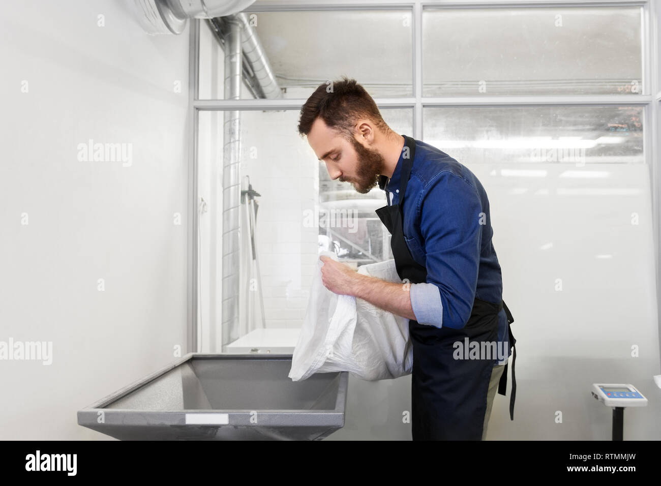brewer pouring malt into mill at beer brewery Stock Photo - Alamy