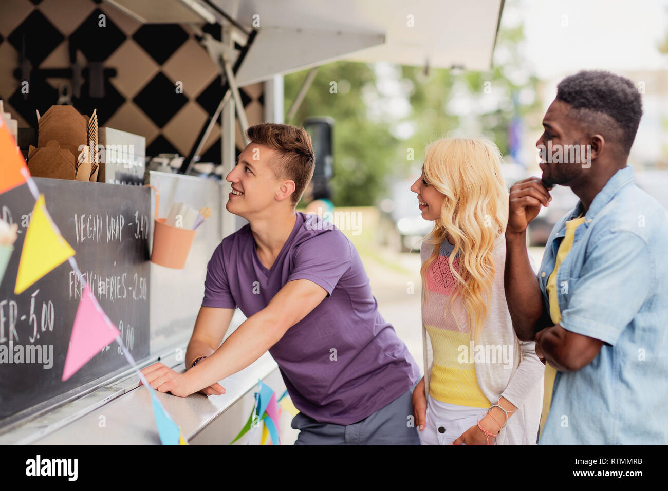 happy customers queue or friends at food truck Stock Photo - Alamy