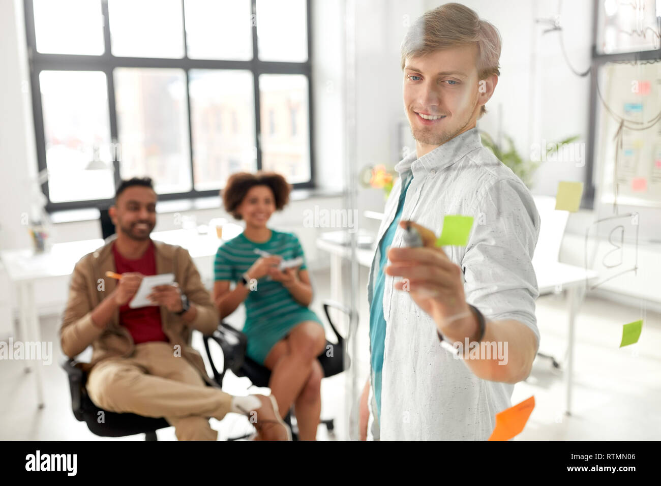 creative team with scheme on office glass board Stock Photo - Alamy