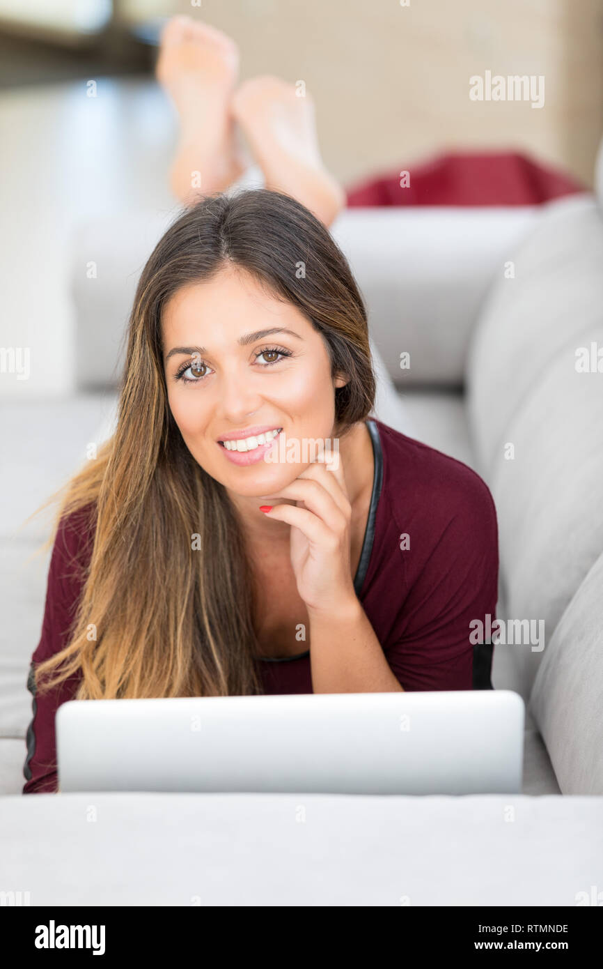 Beautiful young woman relaxing at home on her laptop computer Stock ...