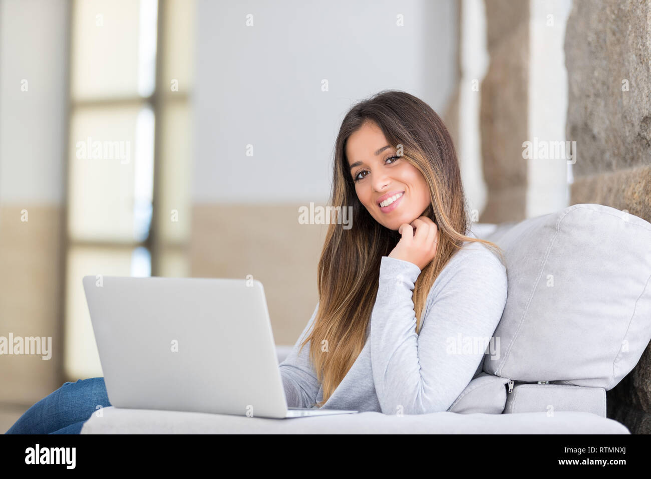 Beautiful young woman relaxing at home on her laptop computer Stock ...