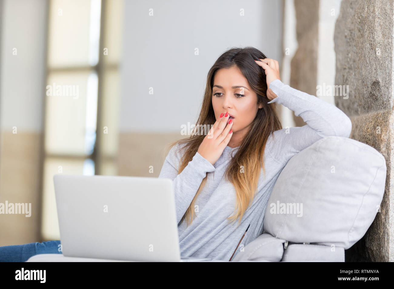 Beautiful young woman relaxing at home on her laptop computer Stock ...